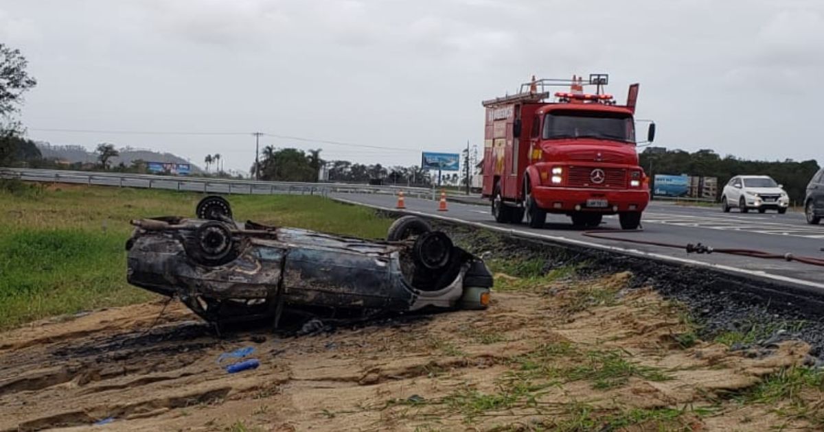 Carro capotado e em chamas mobiliza Corpo de Bombeiros na BR-470, em Ilhota